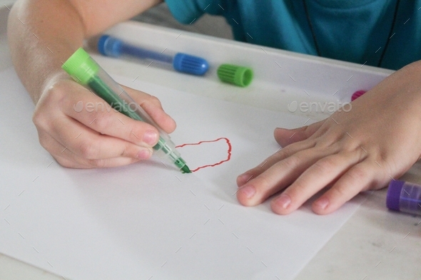 child's hands drawing with colored felt-tip pens on white paper Stock ...
