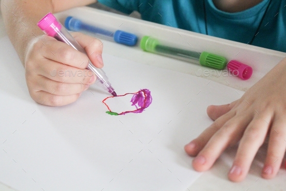 child's hands drawing with colored felt-tip pens on white paper Stock ...