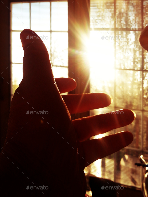 Hand reaching toward the sunrise through windows Stock Photo by marn123424