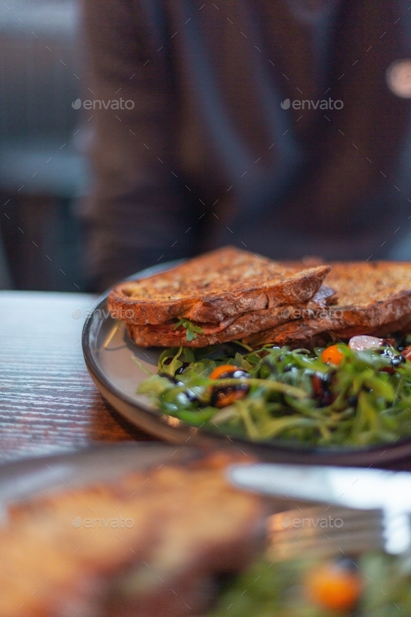 A delicious grilled cheese sandwich with rocket and tomatoes in a pub ...