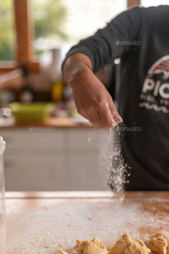 A man flours a surface to shape a brioche dough Stock Photo by StudioAour