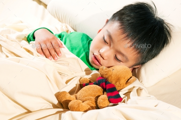 Portrait of a young boy sleeping in bed with teddy bear. Stock Photo by ...