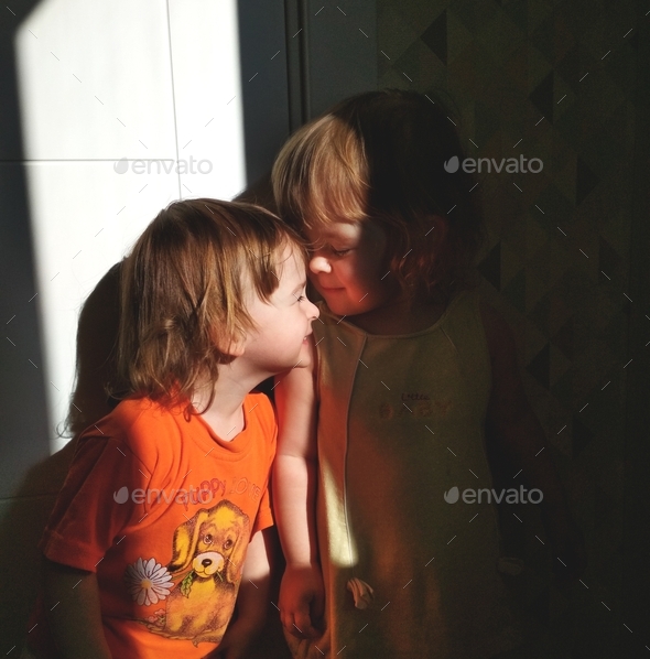 Two children stand side by side and hug Stock Photo by nastya__gennadievna