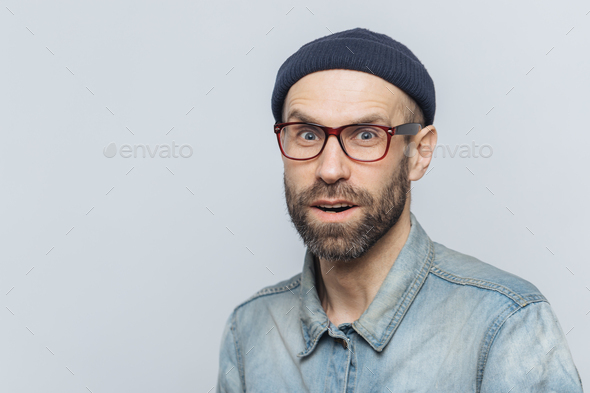 Stylish middle aged male with suprised and curious expression wears ...