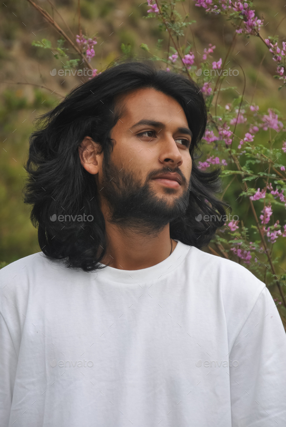 Closeup of a good looking bearded and long haired Indian young men ...