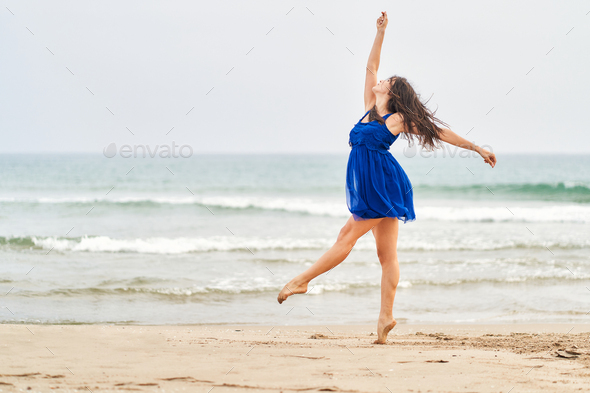 a dancer in a blue dress on the beach performing contemporary modern ...