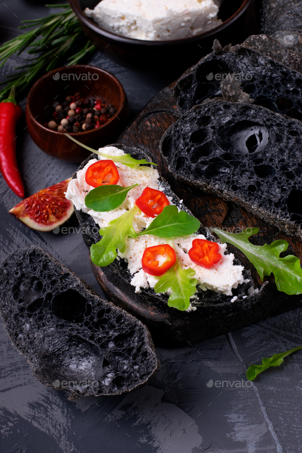 Open-faced sandwich on black ciabatta bread with pepper, lettuce and ...