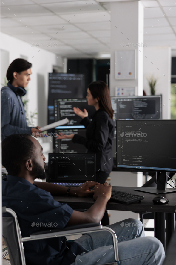 It programmer in wheelchair typing html code in coding office Stock Photo by DC_Studio