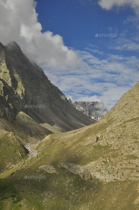 Dry mountains covered with clouds from peak, flowing water from top of ...