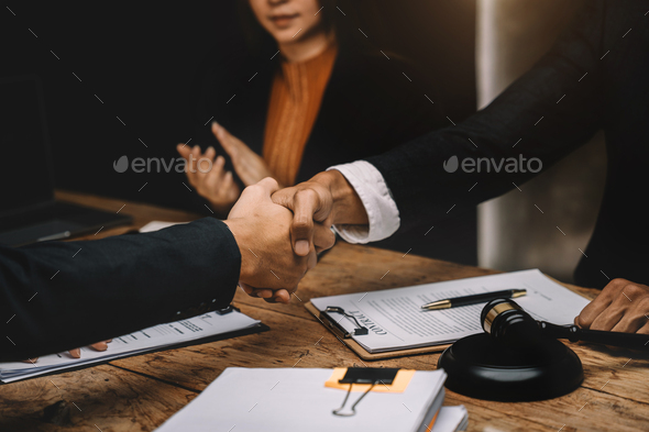 Middle age partner lawyers attorneys shaking hands after discussing a ...