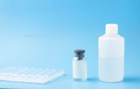 Medical bottles with liquid for injection against the blue background ...