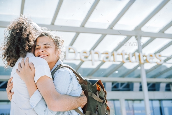 Beautiful couple in love hugging, telling goodbye at the airport ...
