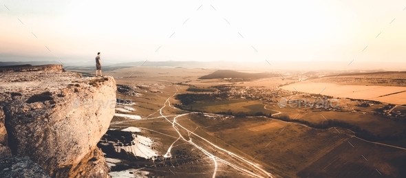 Man standing on the edge of the cliff at the sunset Stock Photo by ...