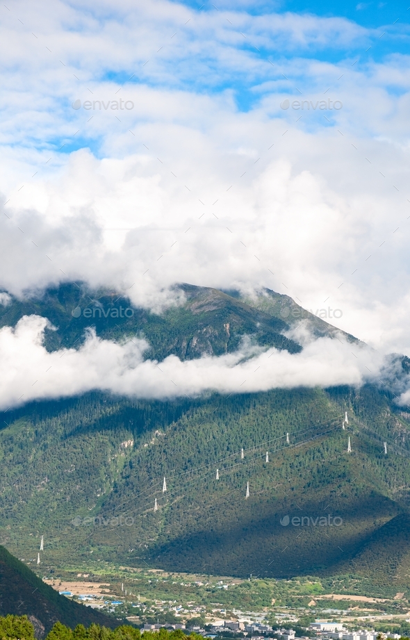 Power transmission towers and lines in the mountain forest in mist ...