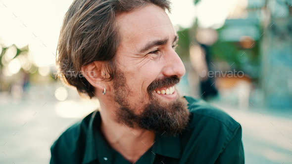 Close-up portrait of a smiling man with a beard on an urban city ...