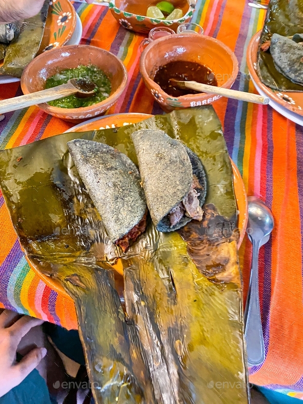 Carnitas Tacos with blue corn tortillas on banana leaves with red and ...