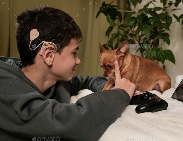 deaf boy with cochlear implant playing computer game on playstation and ...