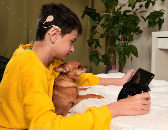 deaf boy with cochlear implant playing computer game on playstation and ...