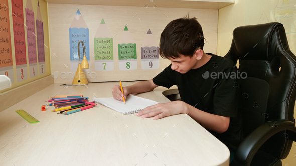 deaf teenager with cochlear implants draws with colored pencils at a ...