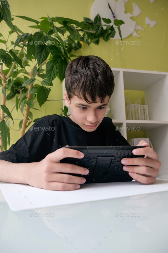deaf teenager with a cochlear implant plays computer games on a tablet ...