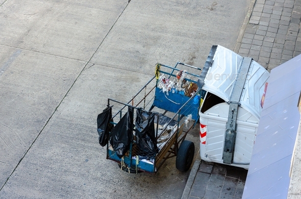 top view of a homeless man pulling a garbage cart on the streets in ...