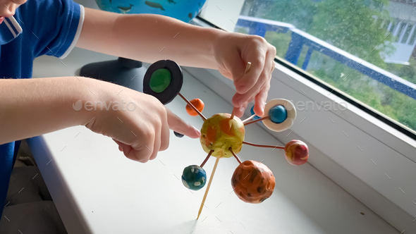 Children's hands hold a model of the planets of the solar system made ...