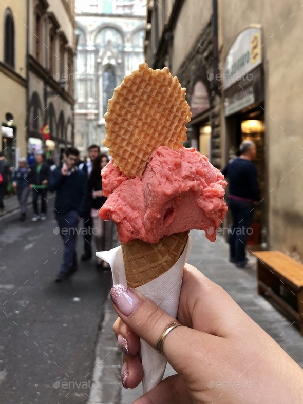 Pink gelato with round waffle in women’s hand Stock Photo by Tashulia