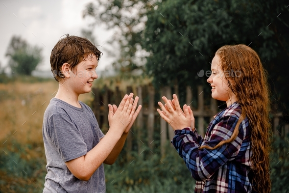 Cute friends enjoying clapping hands, having fun together outdoors ...