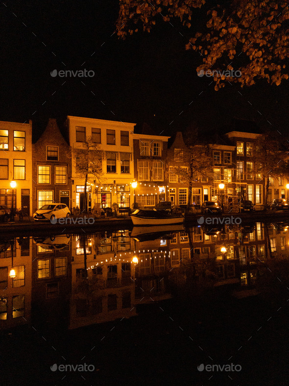 Beautiful houses in the old center at night. Reflection in the water in ...