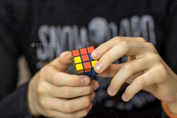 Child wearing casual clothes solving Rubik's Cube. Stock Photo by Dani_Solare