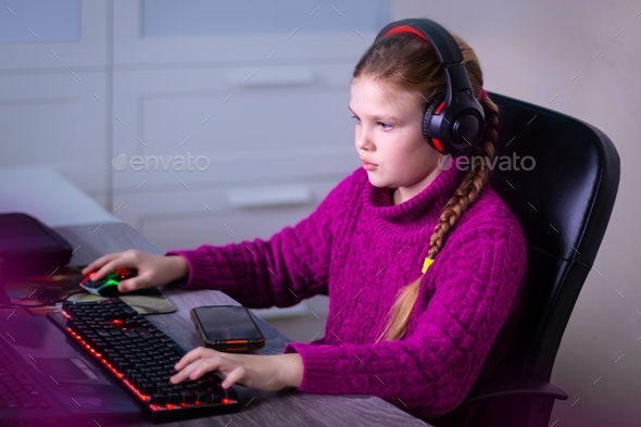 PLAYING VIDEO GAMES. Girl playing video games on a desktop computer ...