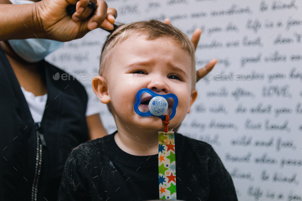 A little boy cries while getting a haircut. Stock Photo by mbannis1