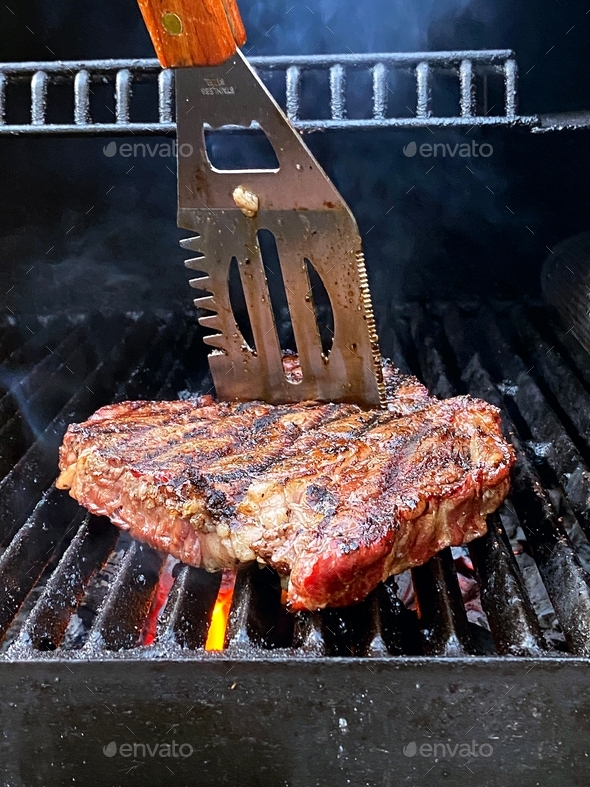 Roasted meat BBQ steak on flaming grill barbecue with smoke.. Outdoor ...