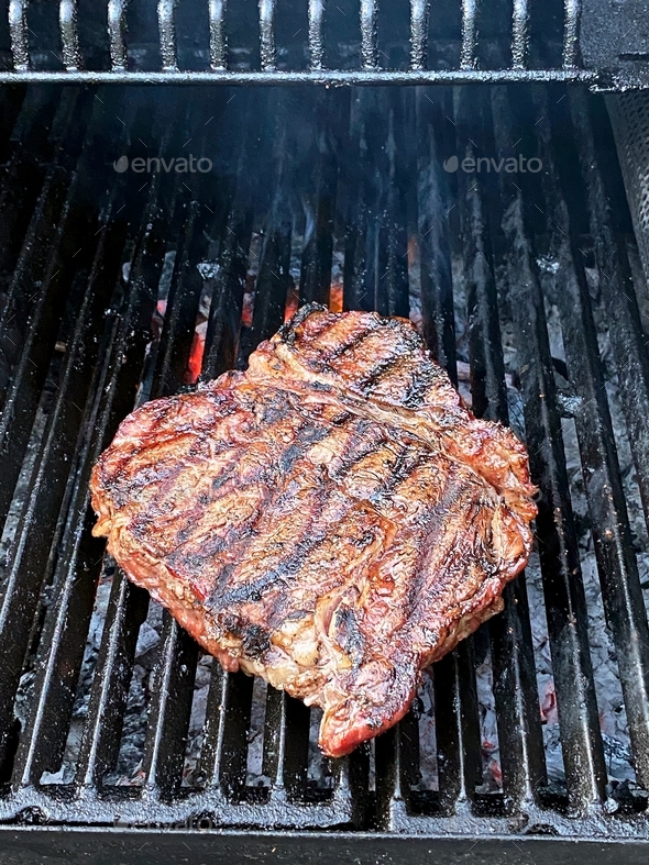 Roasted meat BBQ steak on flaming grill barbecue with smoke.. Outdoor ...