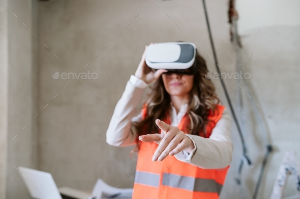 architect woman in construction site using virtual reality goggles ...