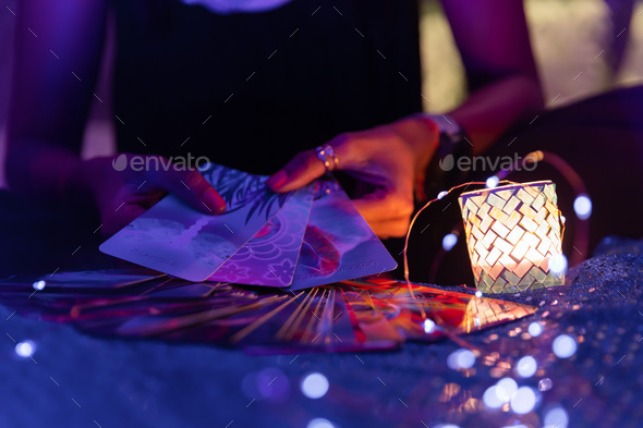 Woman’s hands holding three tarot cards for a reading with fanned out ...