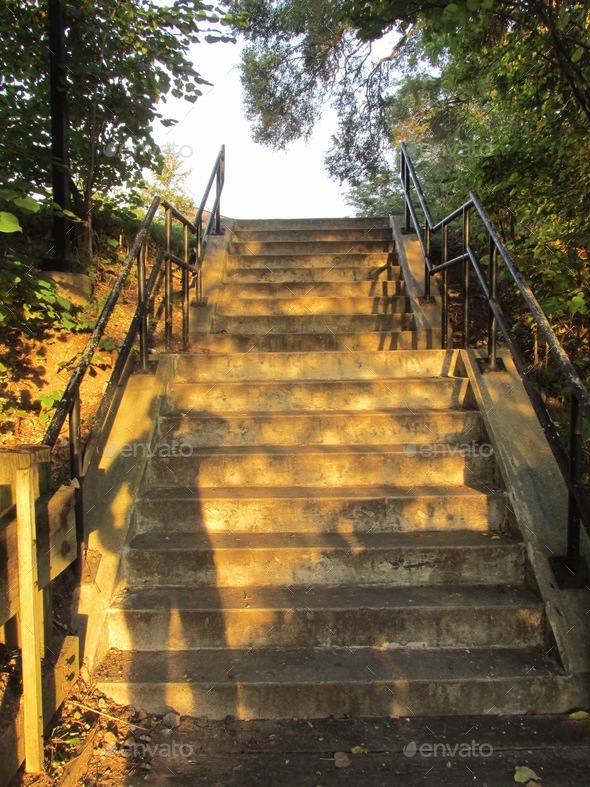 Shadow of person looking ahead and contemplating climbing the steps of ...