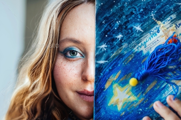 A beautiful, authentic girl with freckles and expressive blue eyes ...