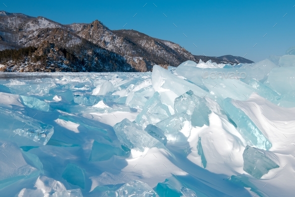 Pieces of crystal clear lake ice with mountains in background Stock ...
