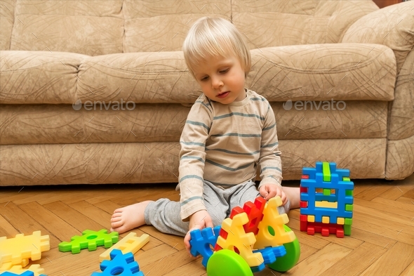 Cute little adorable caucasian boy playing with multi-colored ...
