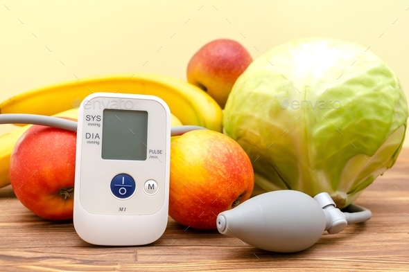 Tonometer and glucose meter,bunch of fresh vegetables,fruits, proper ...