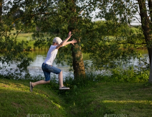 A 6 -year -old boy jumps over the ditch. Summer good mood Stock Photo ...