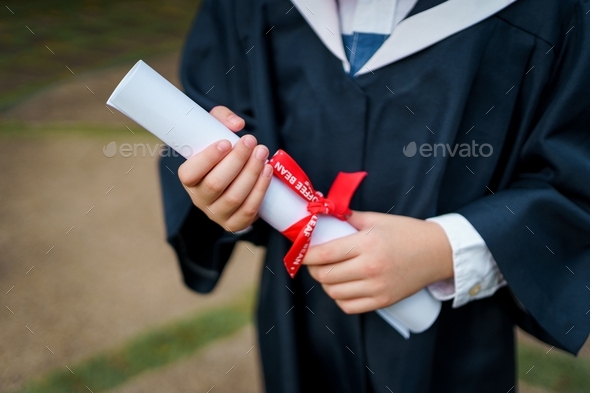 Kids on graduation gown holding graduation scroll Stock Photo by yihchang
