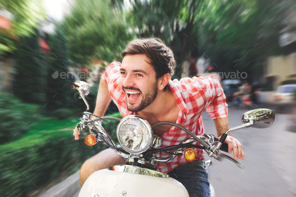 Smiling handsome young man riding scooter Stock Photo by kegfire ...