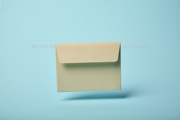 beige and empty envelope on blue background with copy space Stock Photo ...