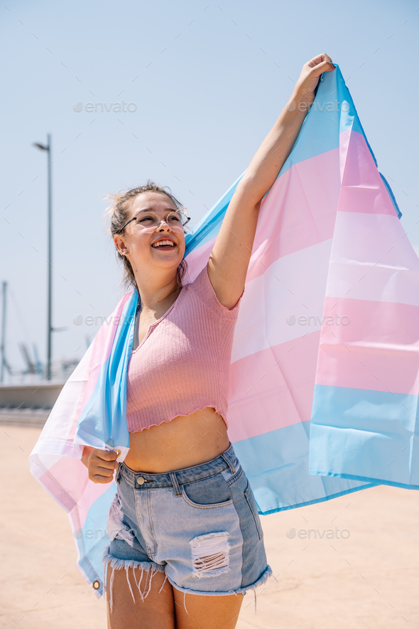 transsexual woman with trans flag, holding a transgender pride flag ...