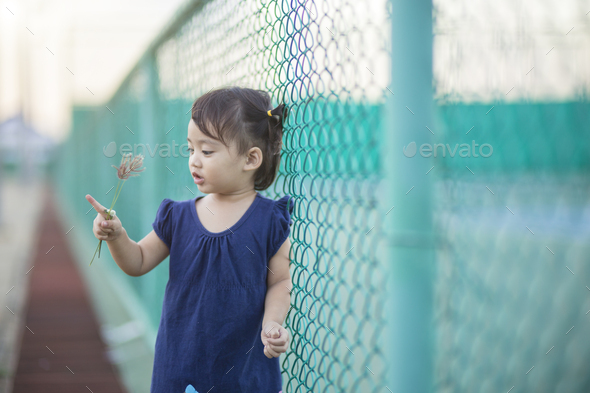 Beautiful little girl picking a dry weed and looking down.Soft Focus ...