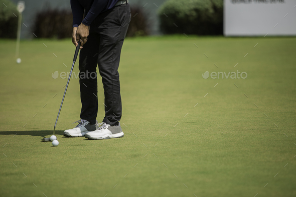 Golf player at the putting green hitting ball into a hole Stock Photo ...