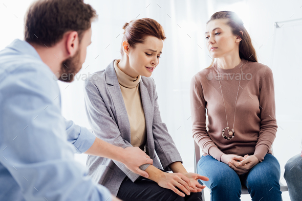 man consoling depressed woman during group therapy session Stock Photo ...