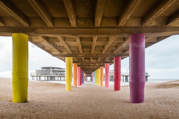 Shot under pier with color painted columns on the beach at sunset Stock ...